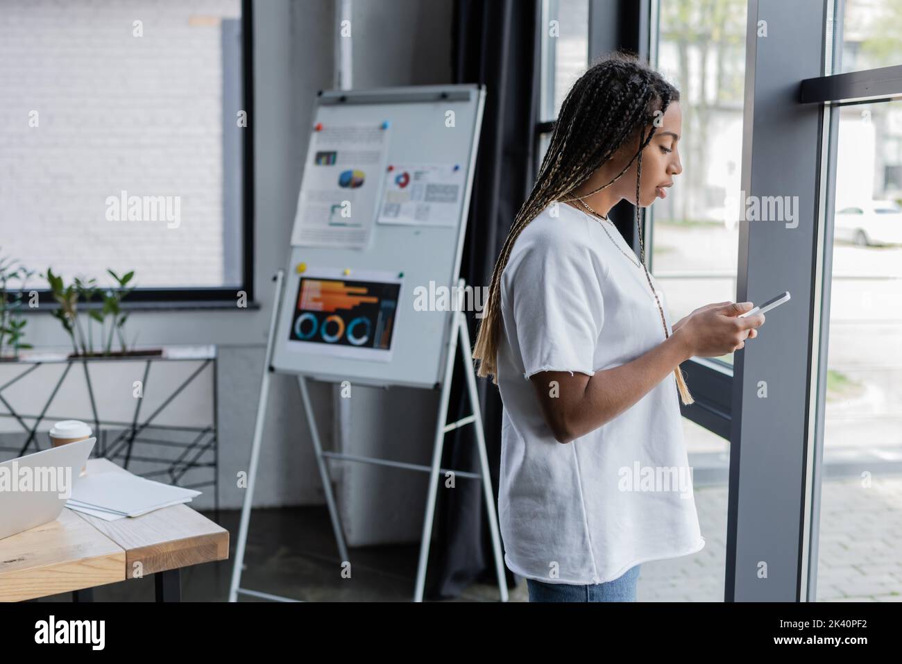 Side view of african american businesswoman using smartphone near ...