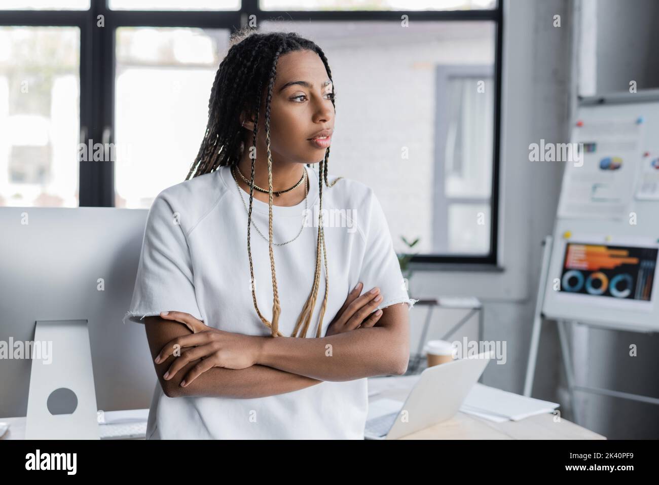 African american businesswoman in t-shirt looking away near devices on ...