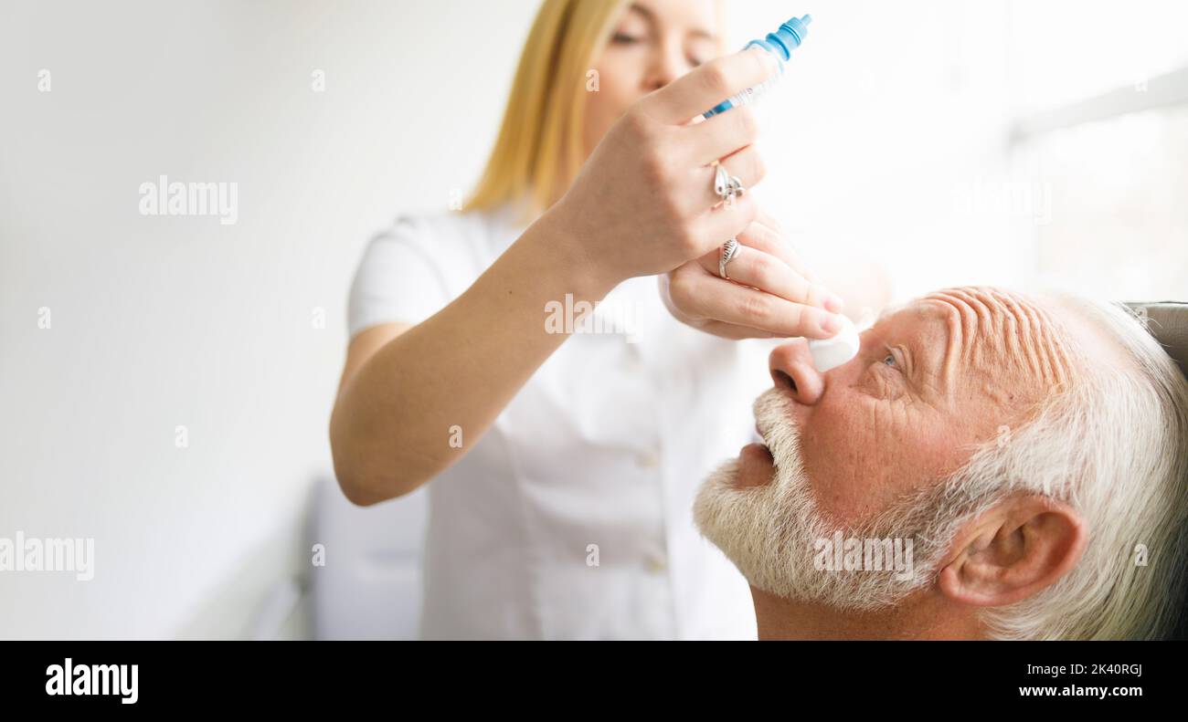 Female doctor giving eye drops to his elderly patient Stock Photo - Alamy