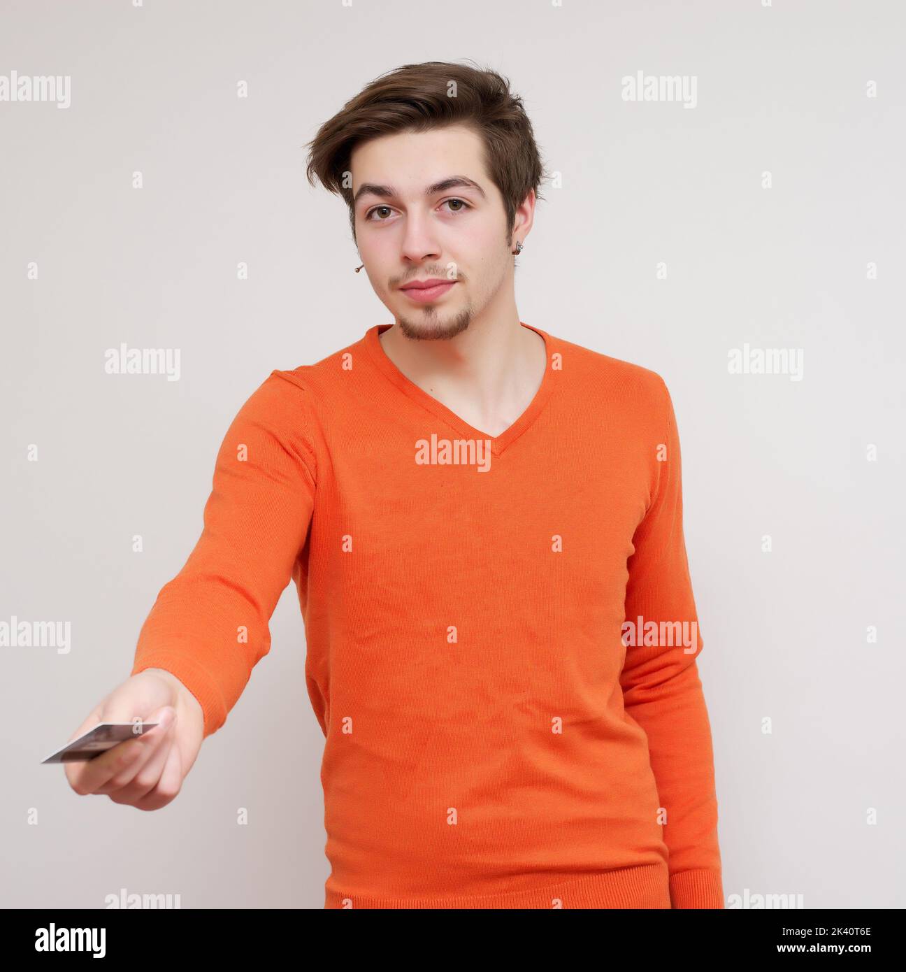 Happy smiling young man holding a credit card isolated on white ...