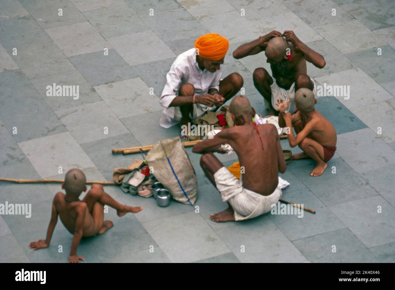 Five person three elder and two boys doing ritual on the bank of ganga ...
