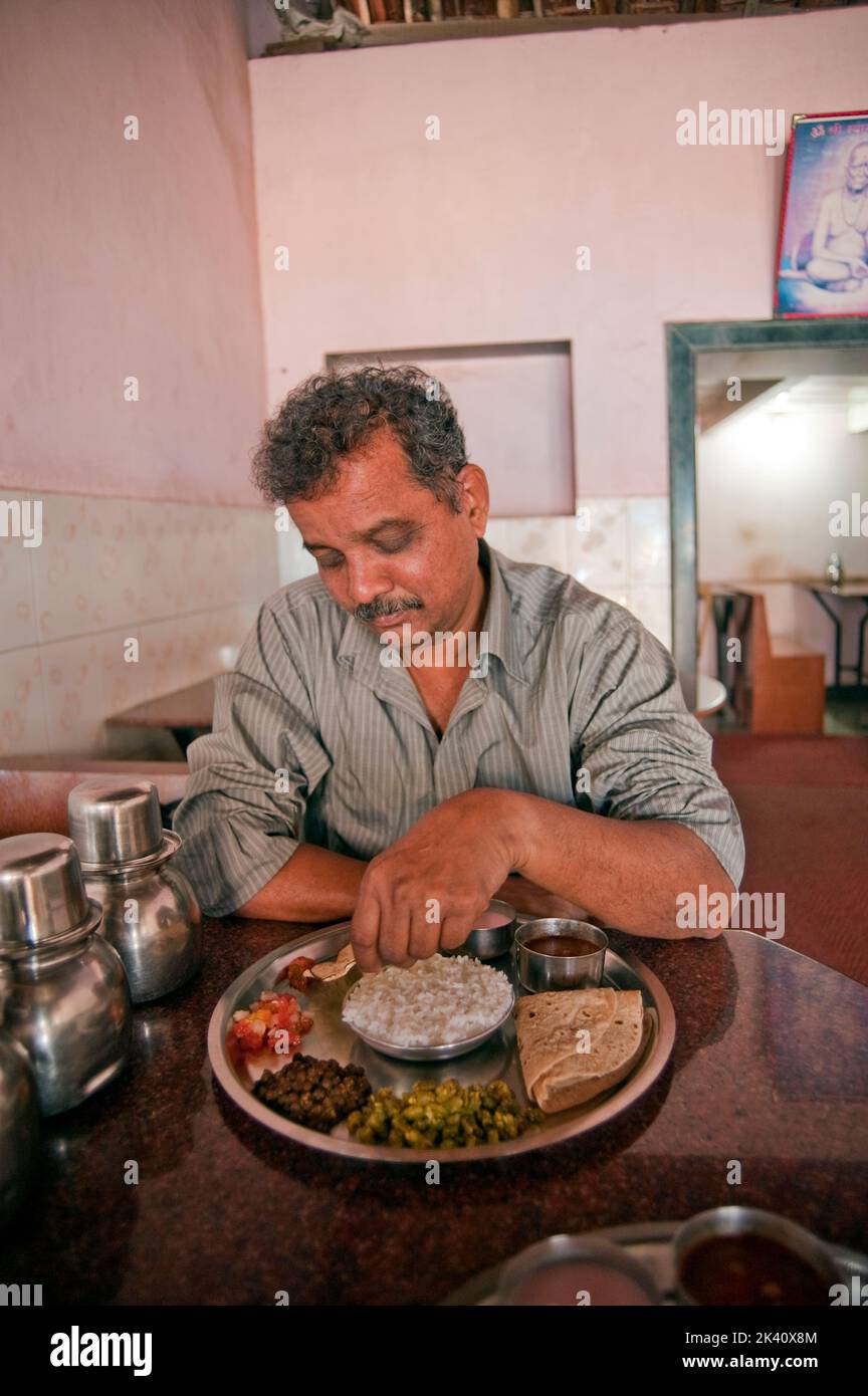 Man eating with his left hand Malvani food a thali in district ...