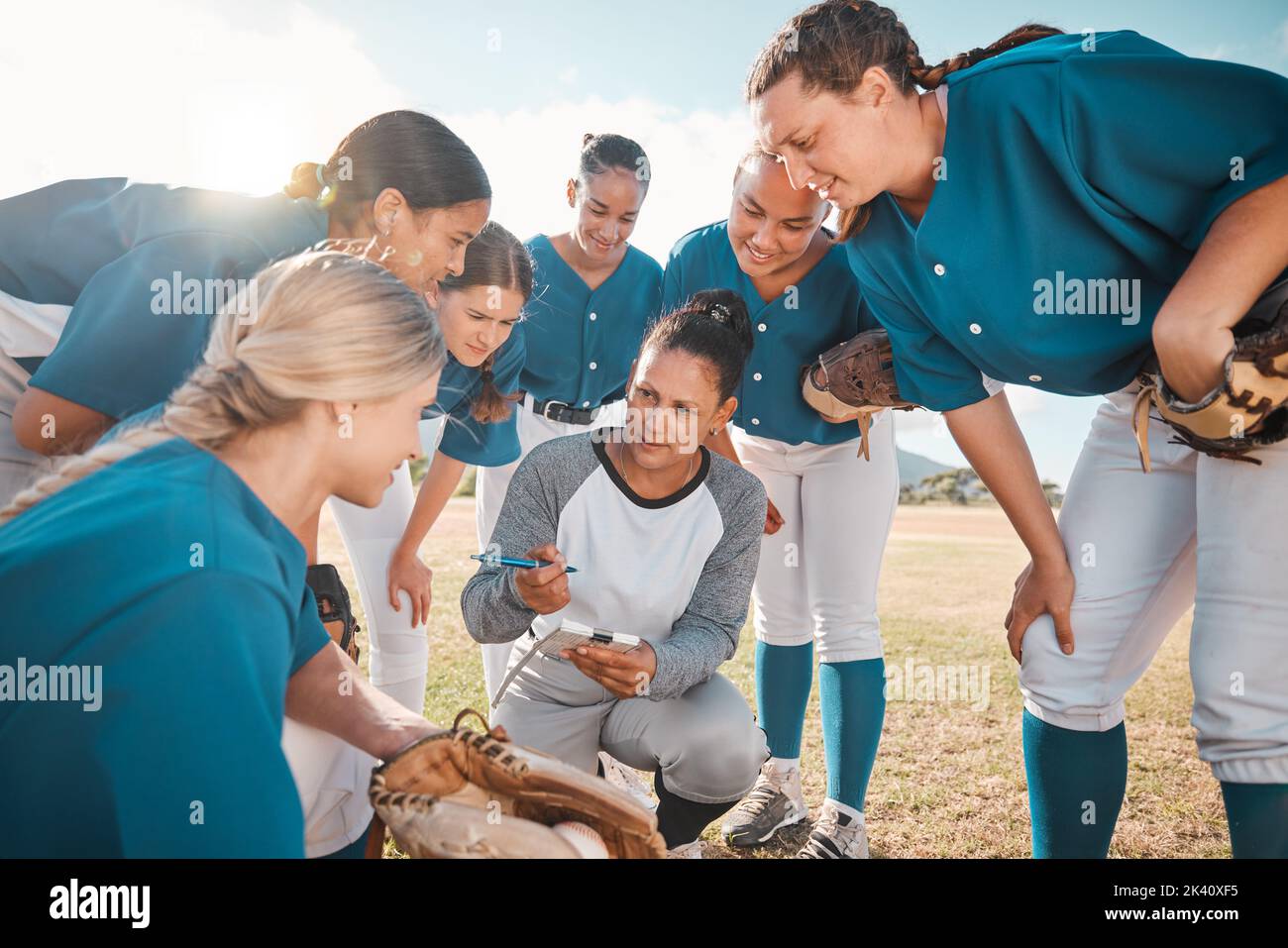 Coach of girl team in softball, planning with players before match or ...