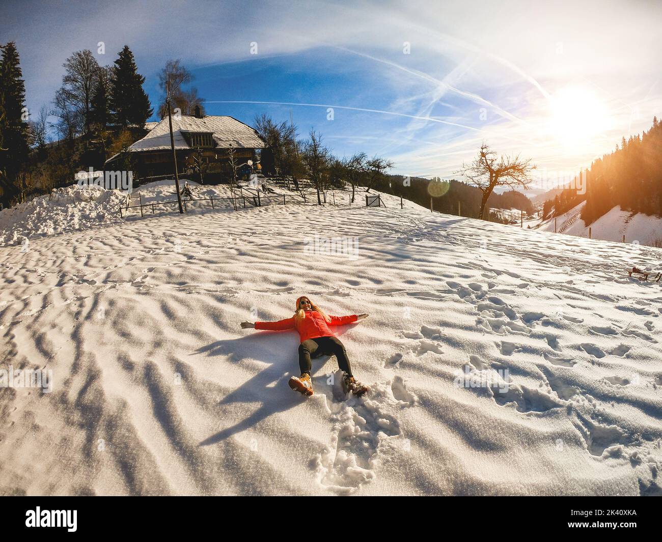 Happy girl having fun making angel shape on fresh snow Stock Photo - Alamy