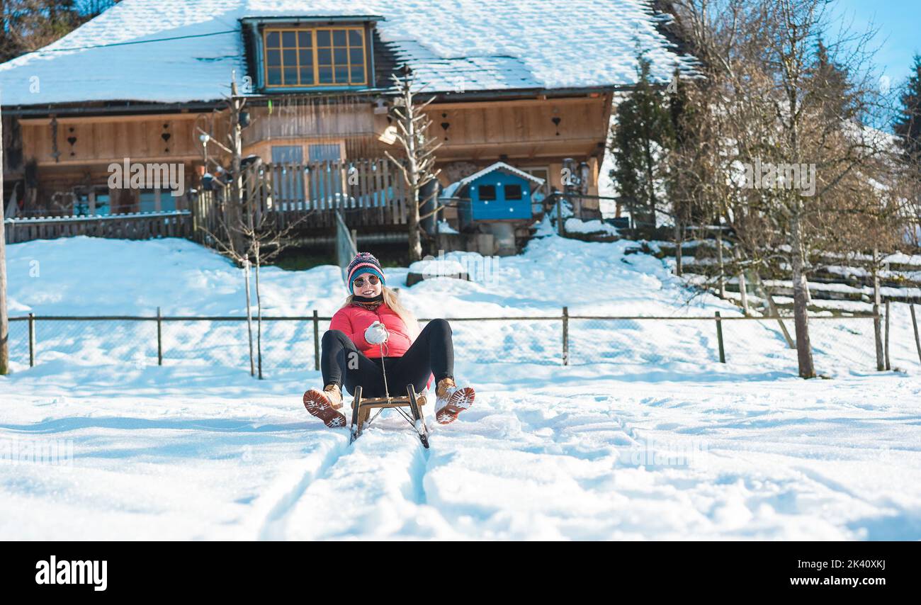 Crazy girl speeding with vintage sledding on snow high mountain - Focus ...