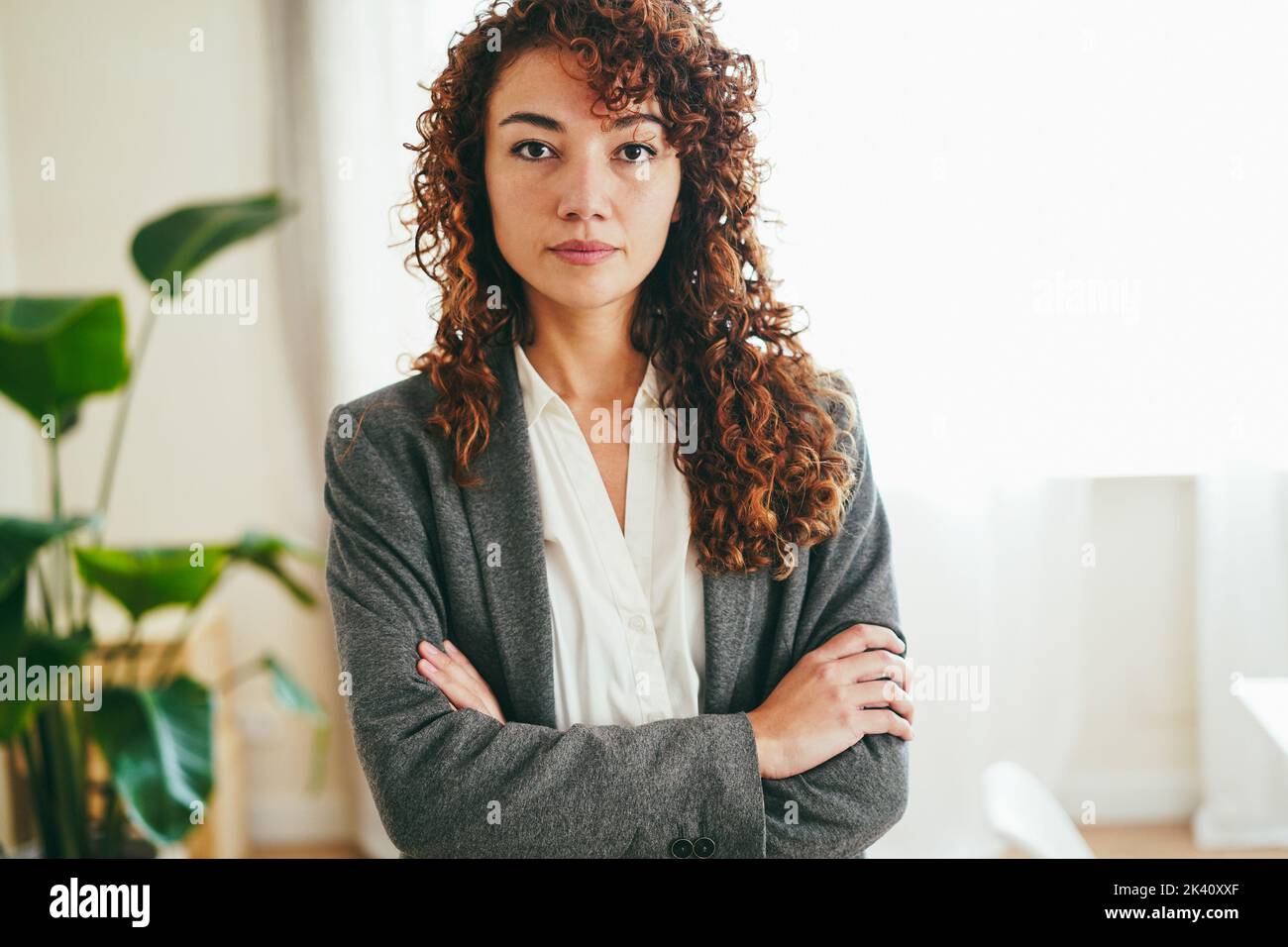 Hispanic young woman looking at camera inside modern office - Focus on ...