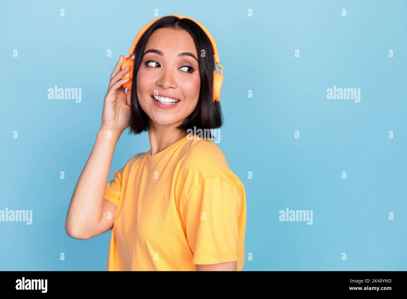 Photo of pretty positive girl hand touch headphones toothy smile look ...