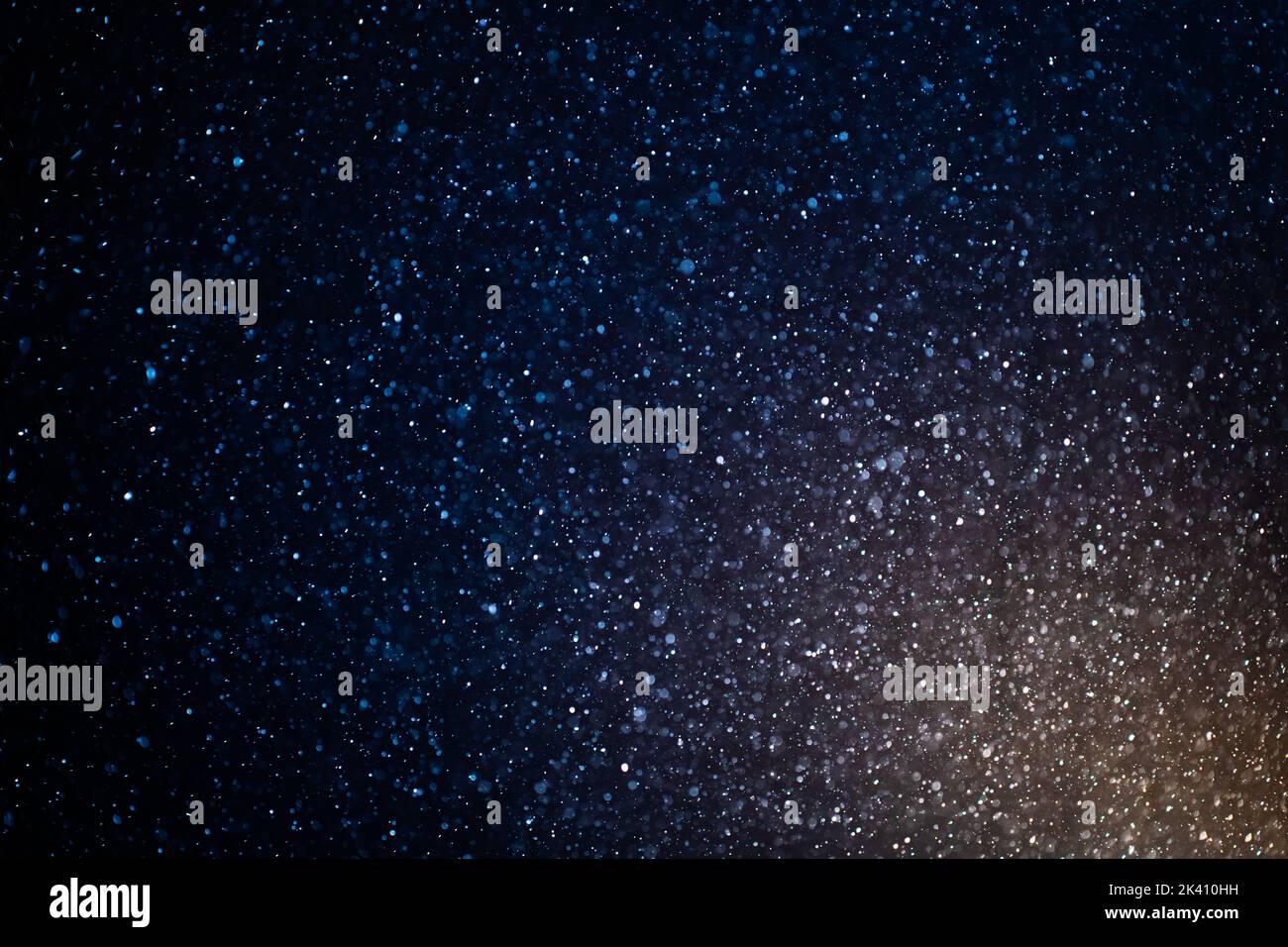Organic dust particles floating on a colorful light beam on black ...