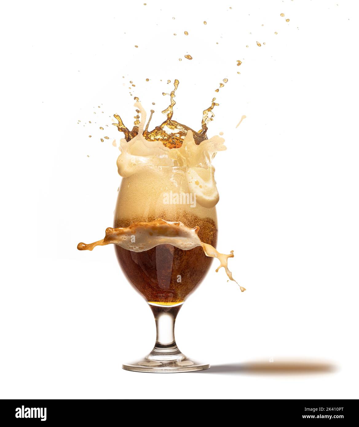 Ice cube falling into beer glass creating huge foam splashes. Glass ...