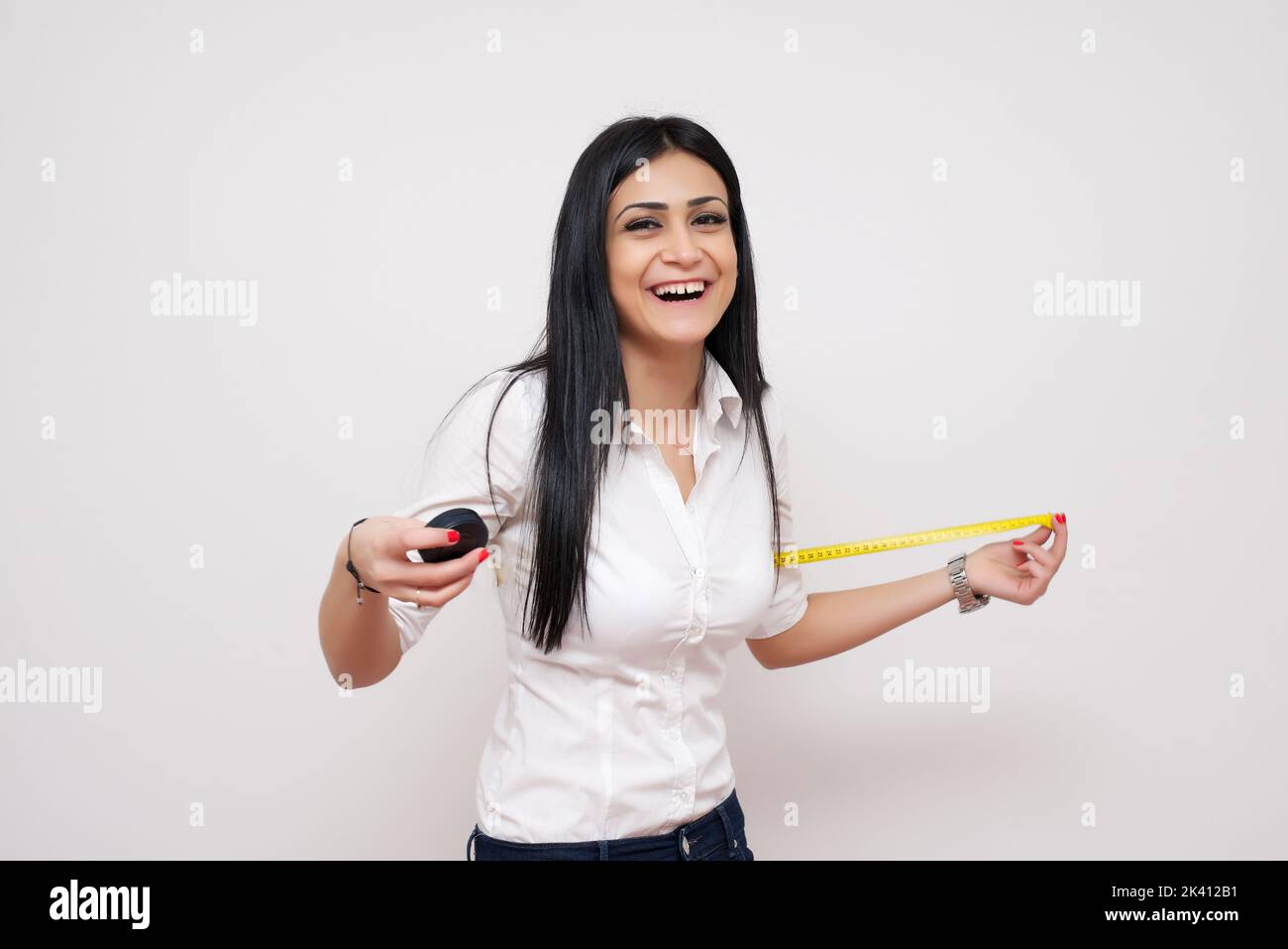 Beautiful young woman measuring her body with tape isolated on white ...