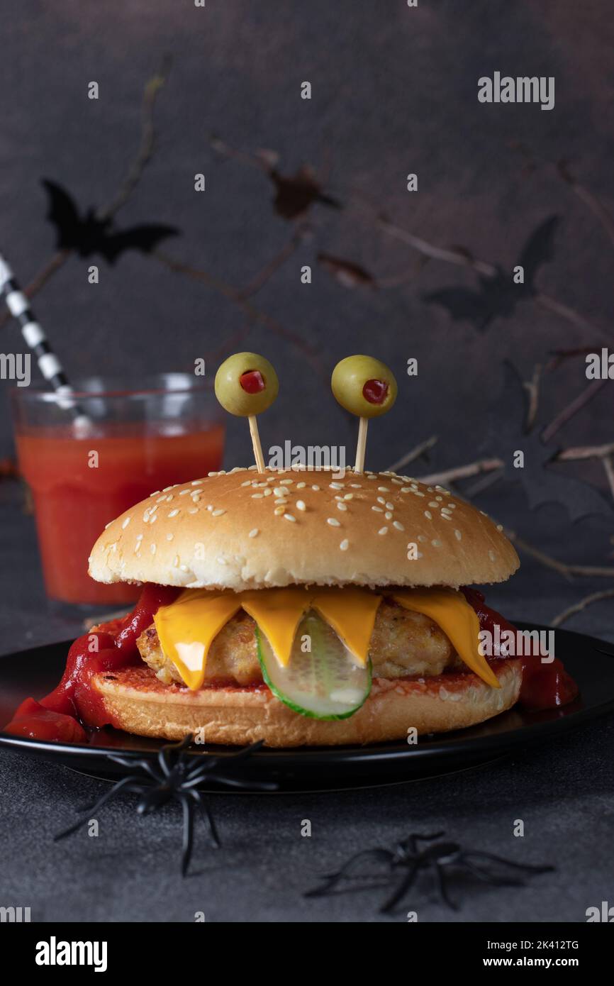 Funny monster chicken burger with toast cheese, ketchup, olives and ...