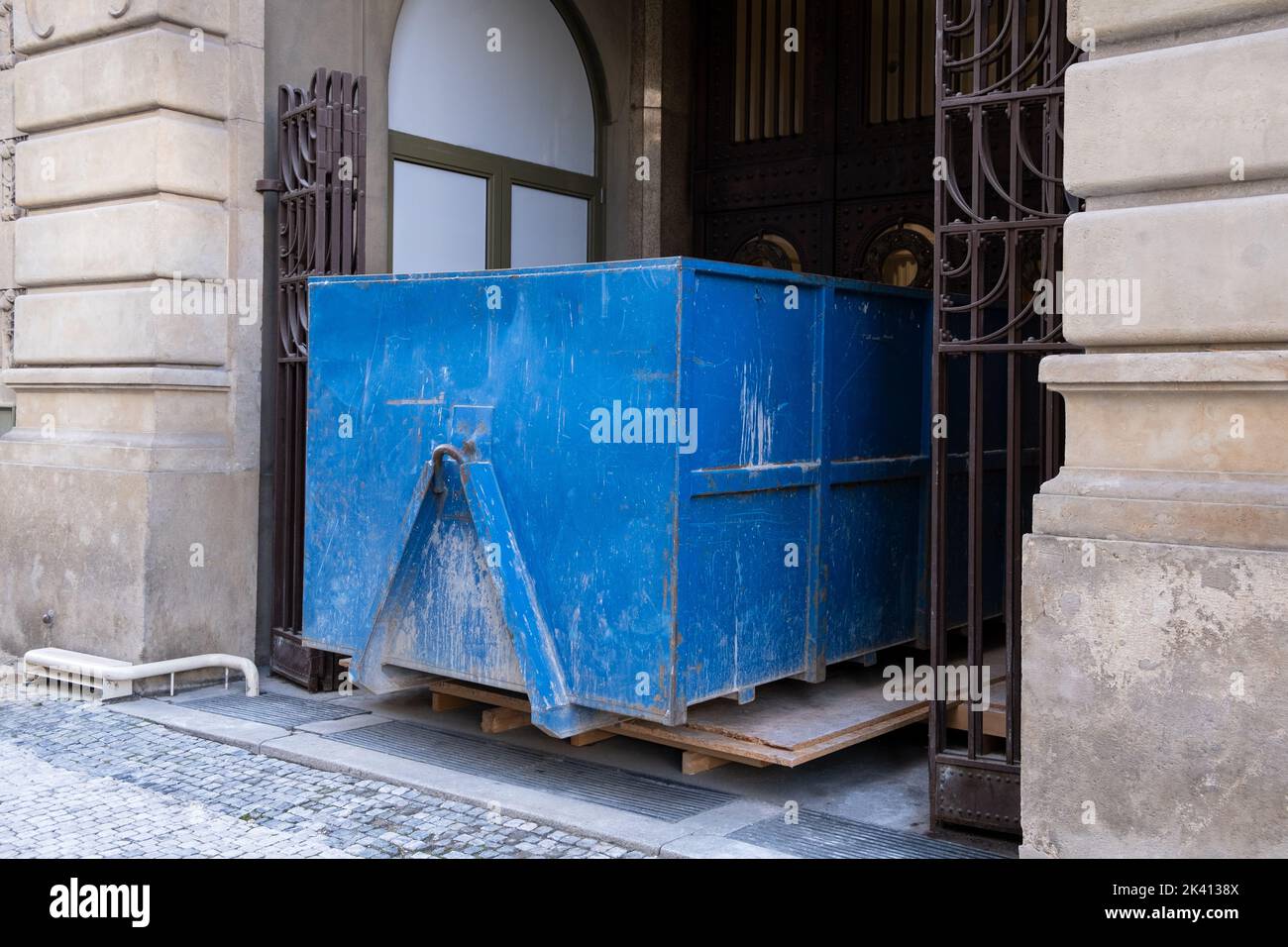 Big blue metal dumpster building waste container filled with ...