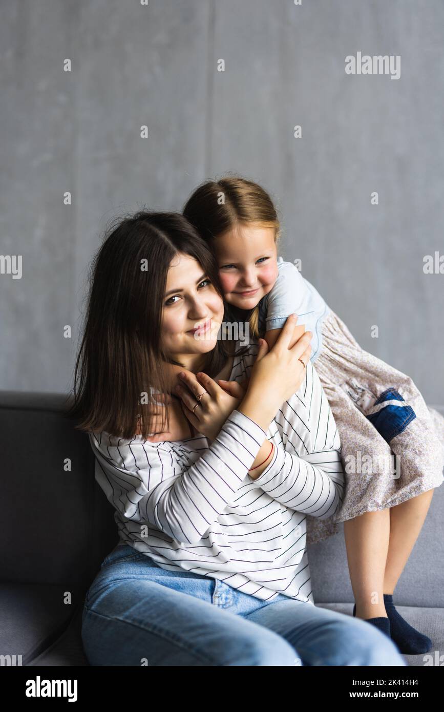 Close up happy attractive mother hugging cute daughter. Smiling young ...