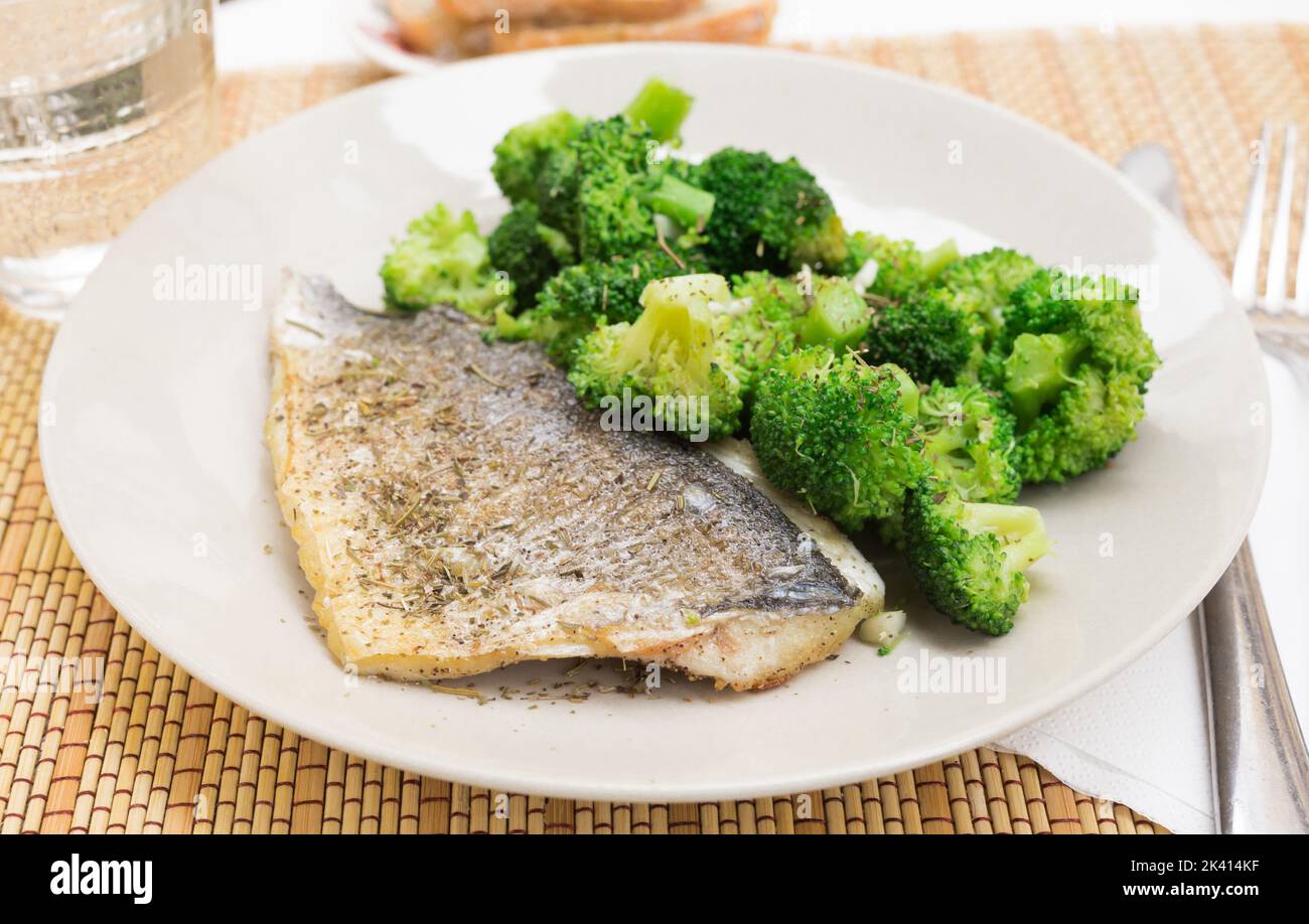 dish of fried dorado fish fillet with boiled broccoli Stock Photo - Alamy