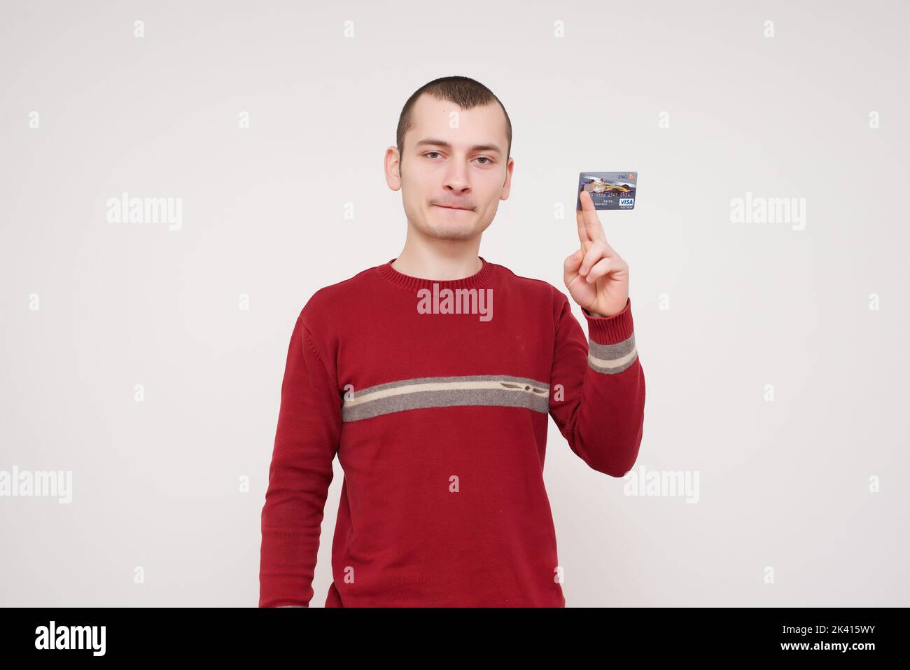 Happy smiling young man holding a credit card isolated on white ...