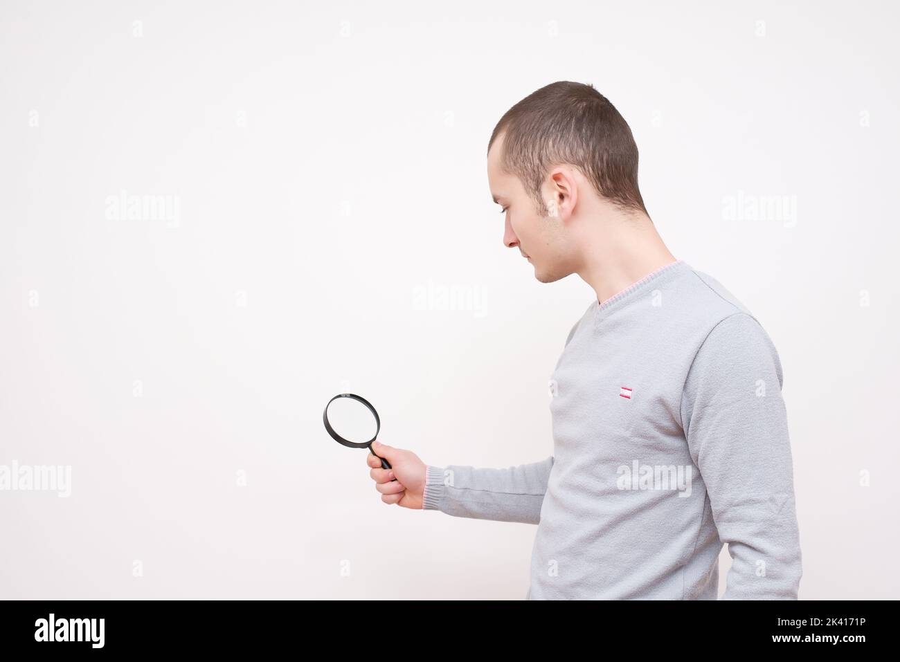 Young man look through magnifying glass stock photo Stock Photo - Alamy