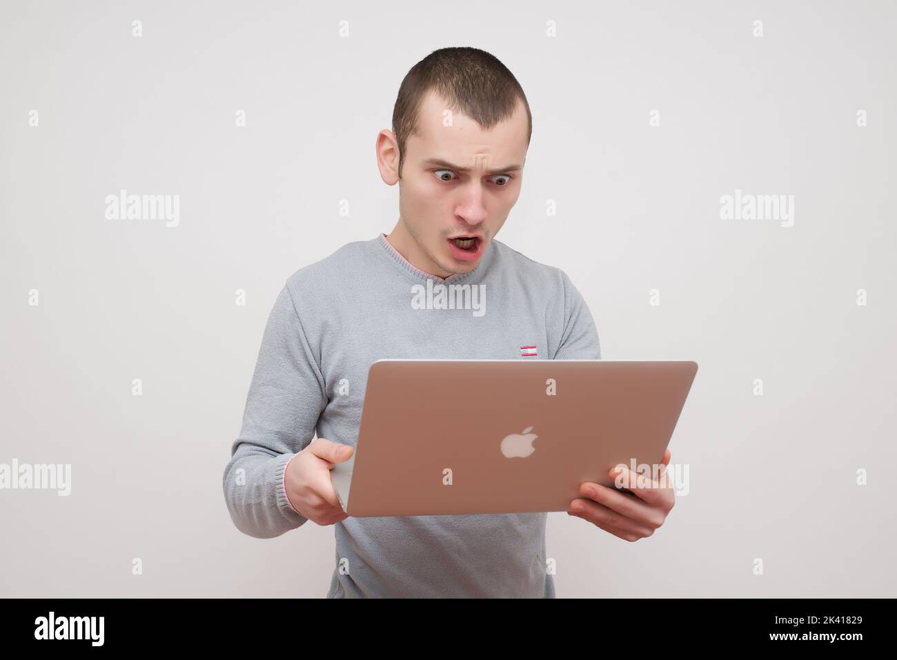 Confident young man with laptop standing over white background. stock ...