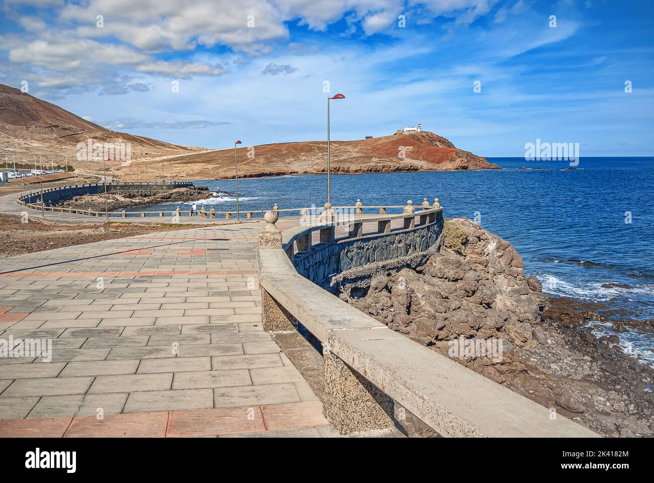 Empty stone embankment. View of ocean andl lighthouse at entrance pier ...
