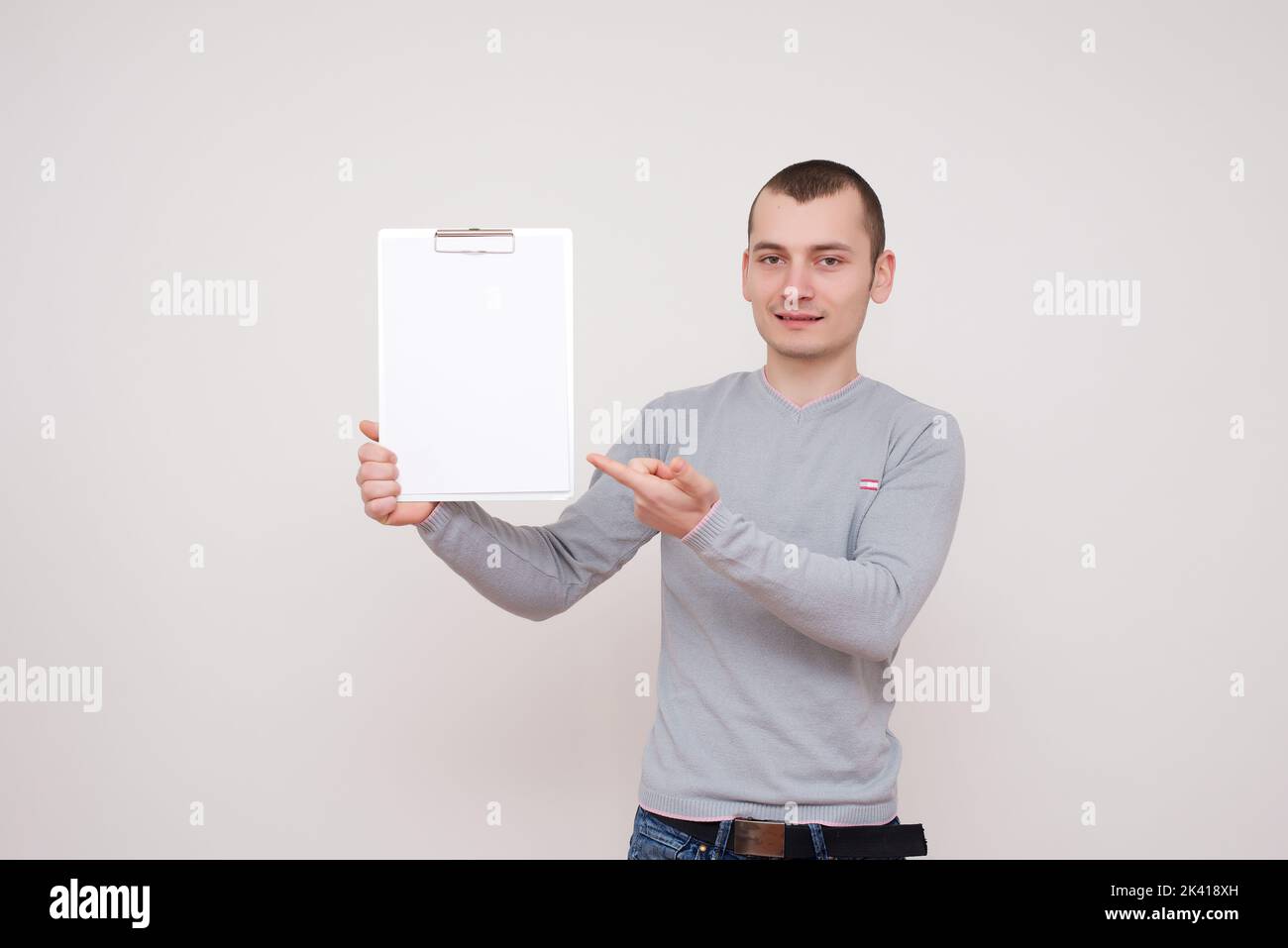 Happy smiling young business man showing blank signboard, isolated over ...