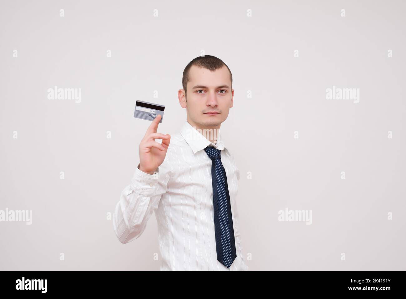 Happy smiling young man holding a credit card isolated on white ...