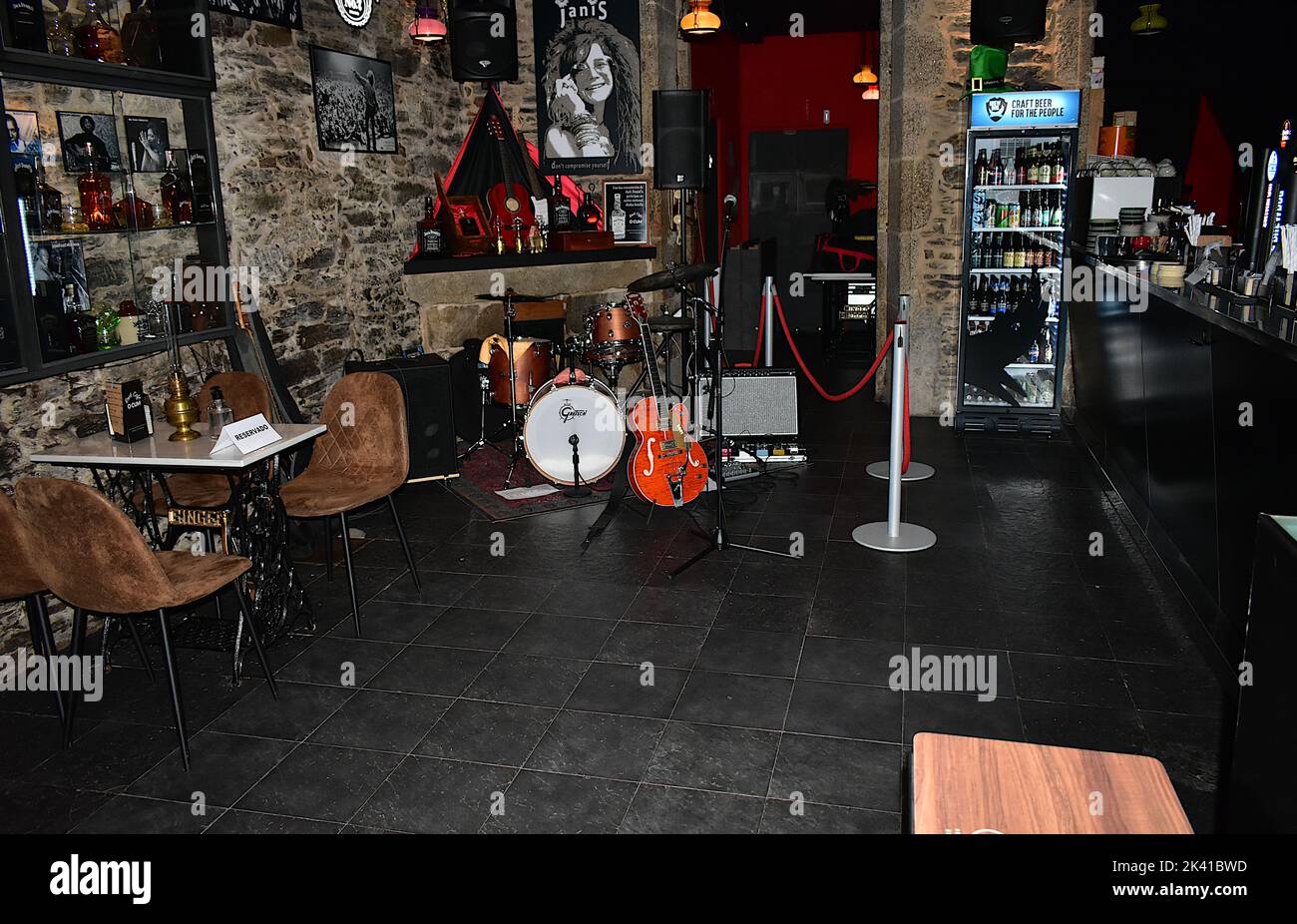 A bar stage ready for live music with a Gretsch guitar and drums, and a ...