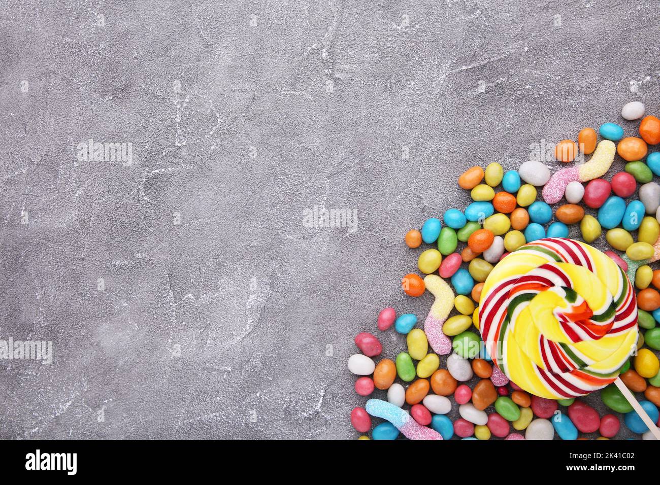 Colorful lollipops and different colored round candy on grey Stock ...
