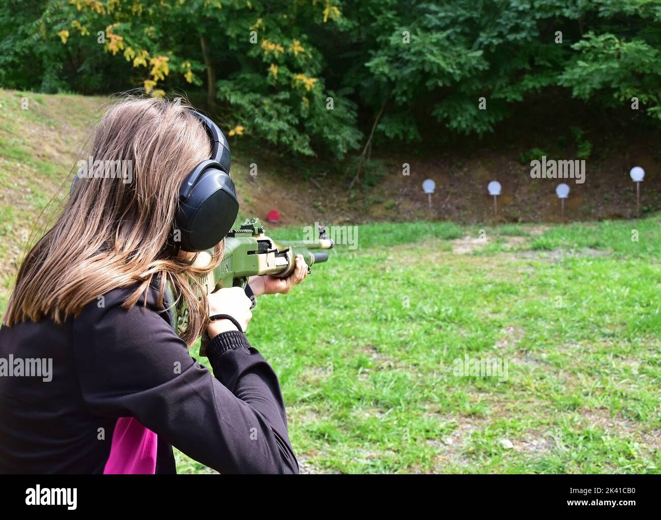Woman with a gun at the sport shooting competition Stock Photo - Alamy