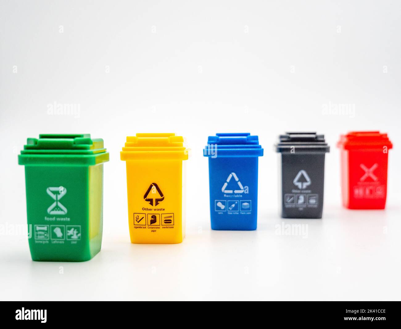 various colored recycle bins for different type of trash on white ...