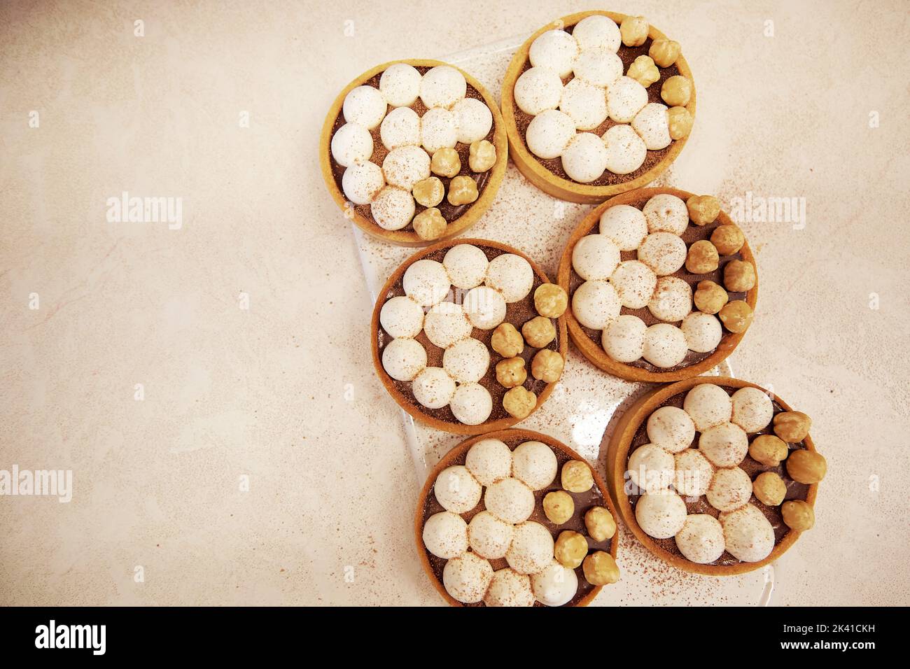 French aesthetic hazelnut creamy tarts in the row. Vintage background ...