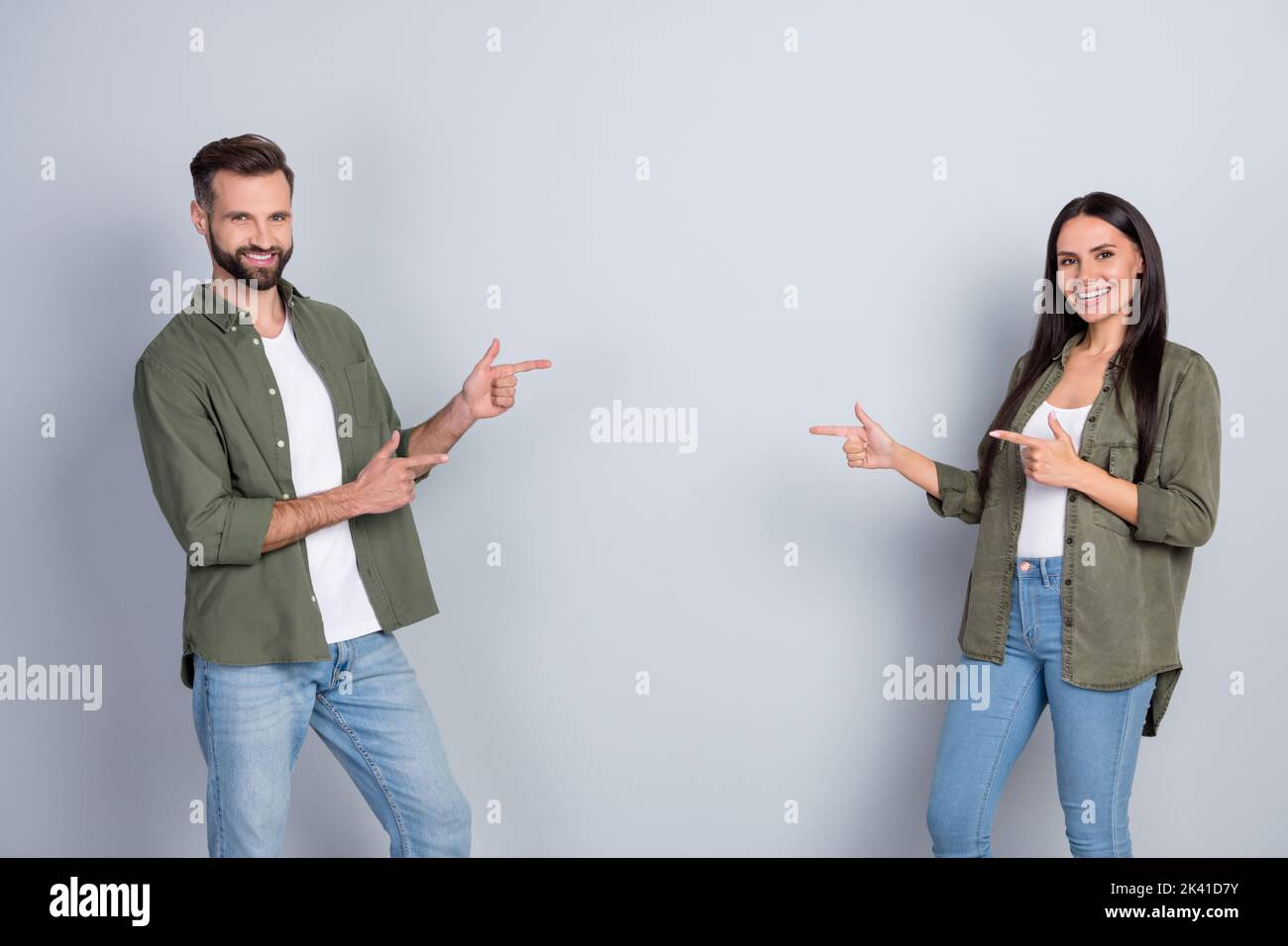 Portrait of attractive cheerful couple demonstrating copy space advert ...