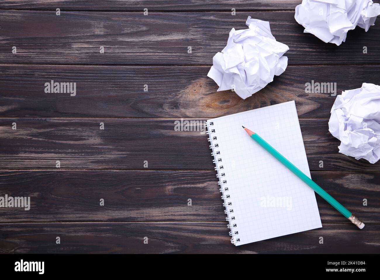 Writing concept - crumpled up paper wads with a sheet of white paper ...