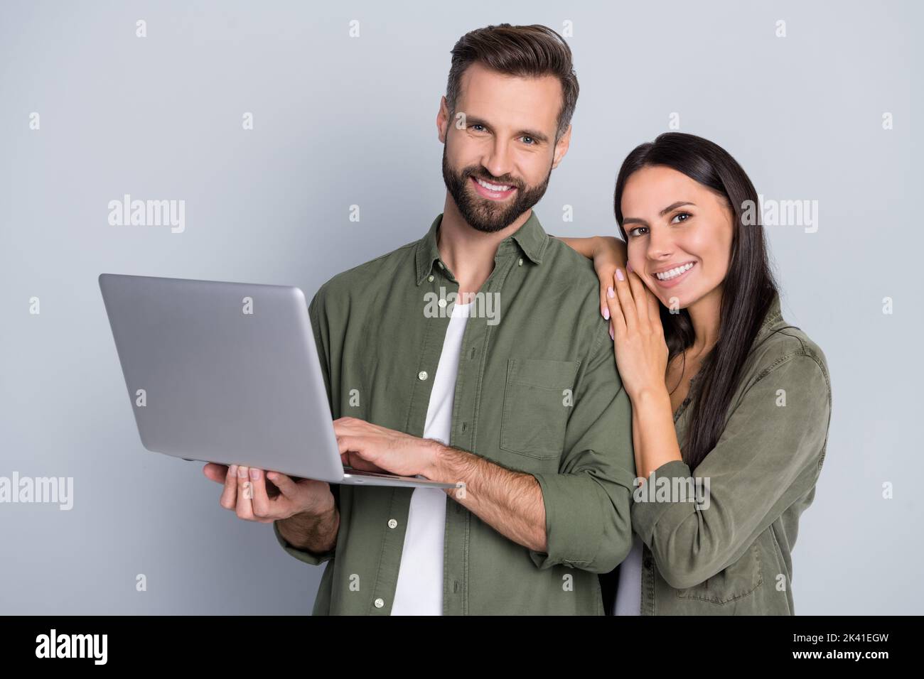 Portrait of attractive cheerful couple cuddling using laptop web ...