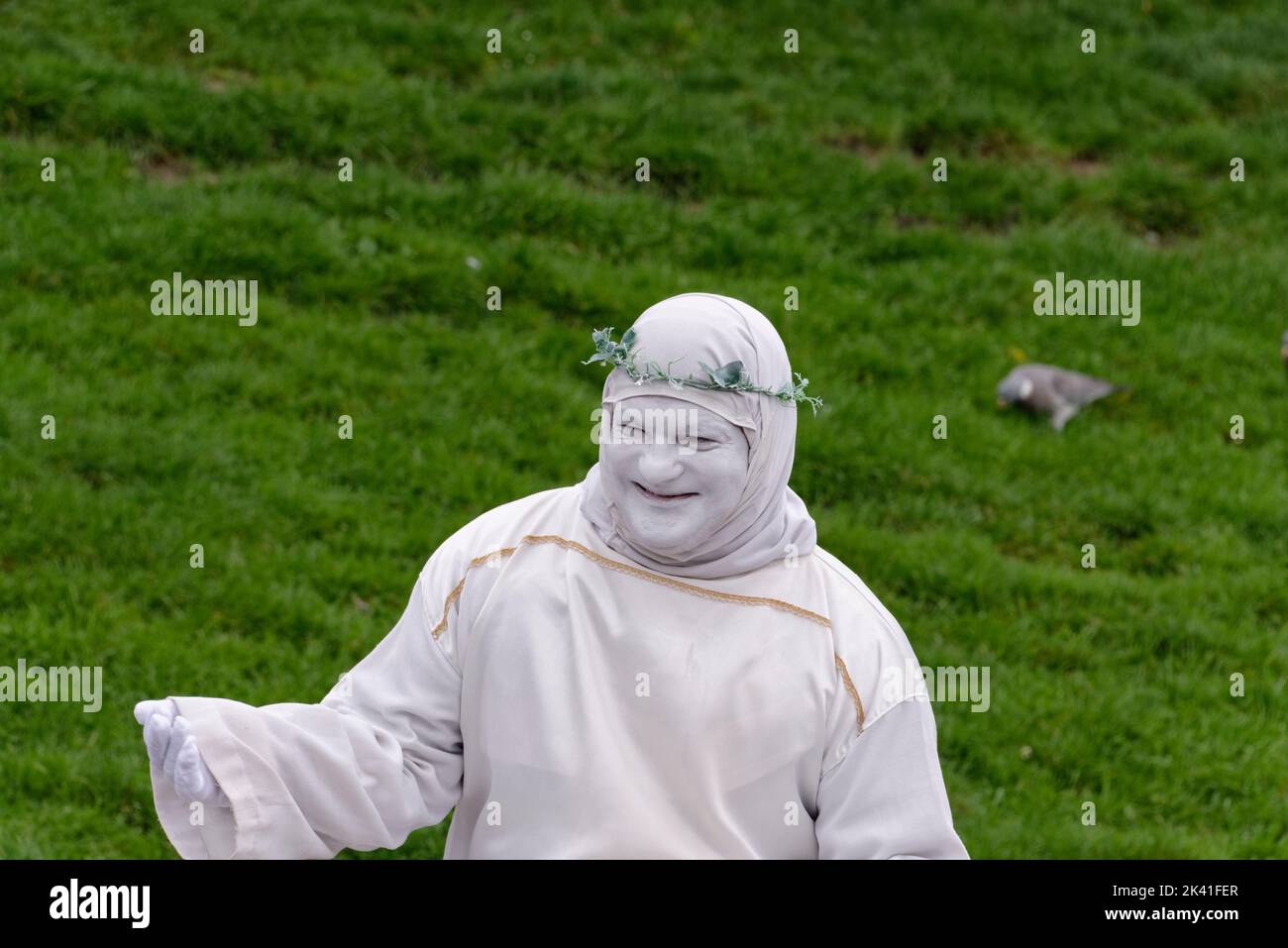 Street artist playing disguised as a white statue Stock Photo - Alamy