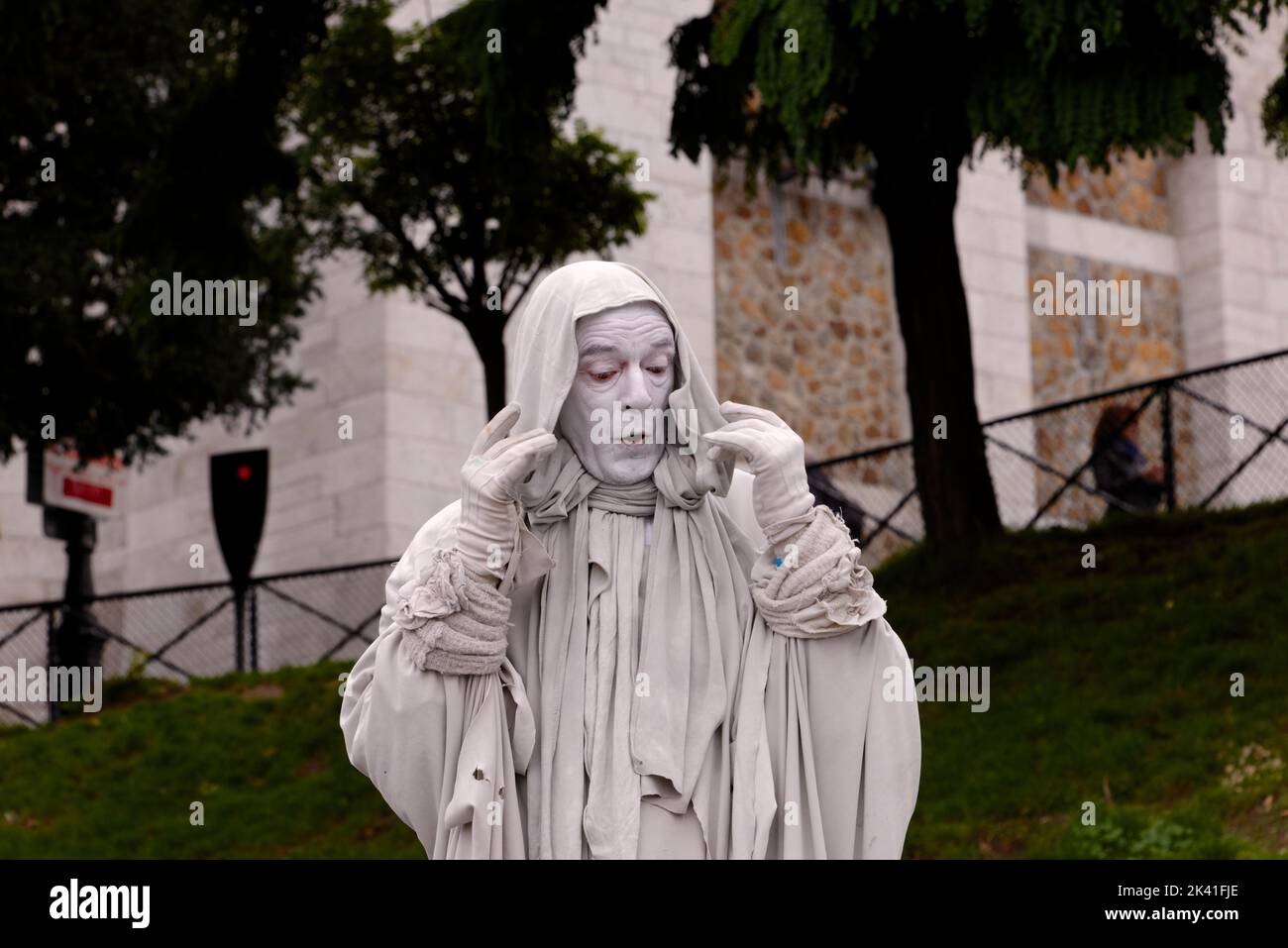 Street artist playing disguised as a white statue Stock Photo - Alamy