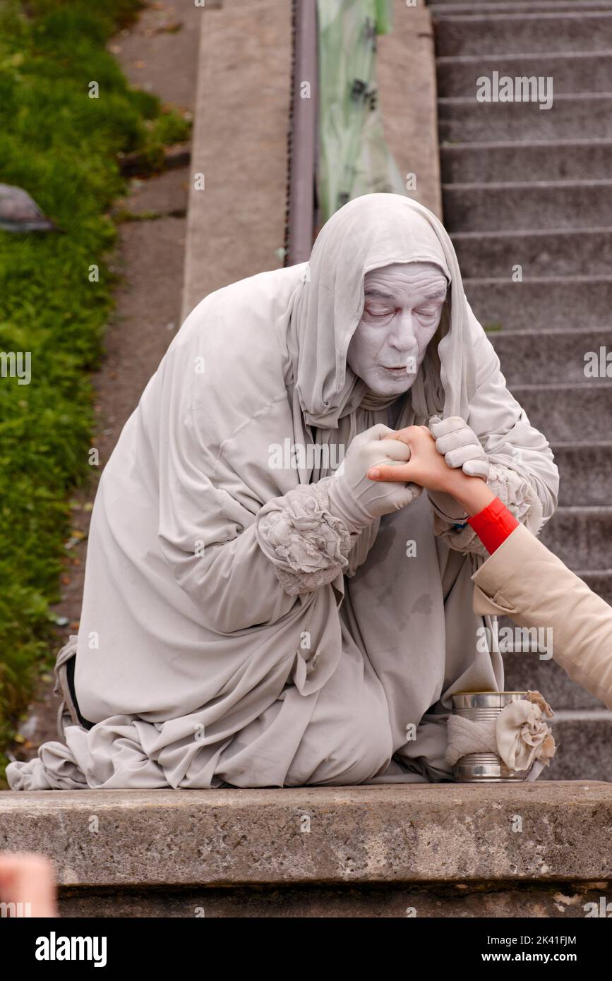 Street artist playing disguised as a white statue Stock Photo - Alamy