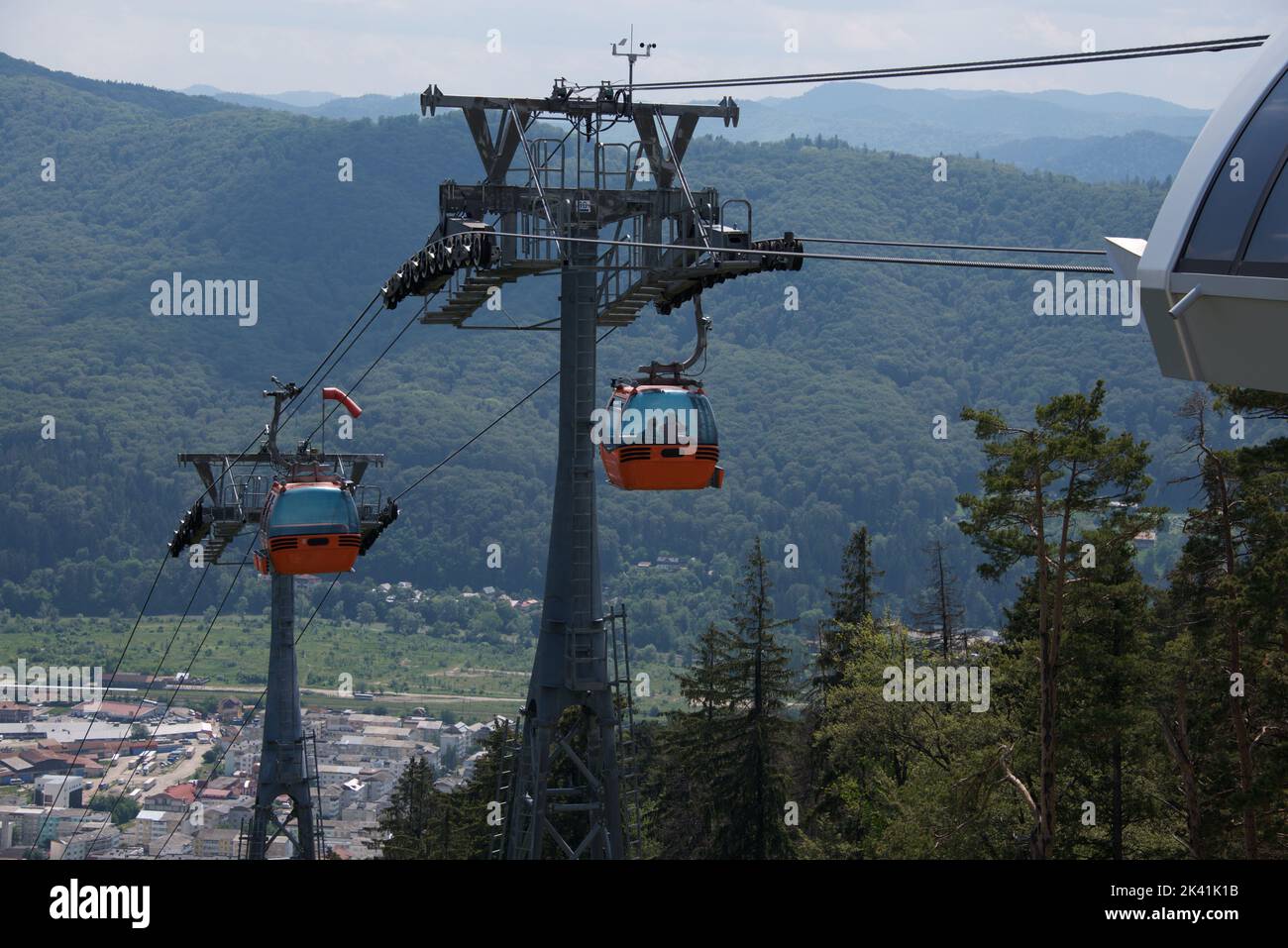 Urban cable car running across the forest and city Stock Photo - Alamy