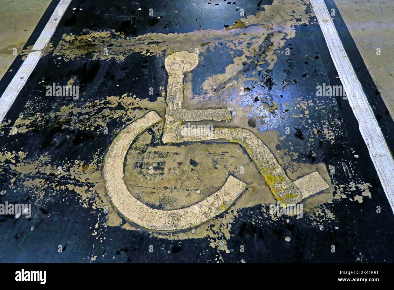 Worn disabled sign on pathway Stock Photo - Alamy