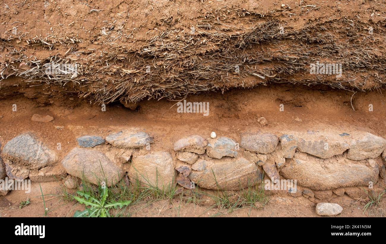 Close-up background of the wall of an old house made of clay mixed with ...