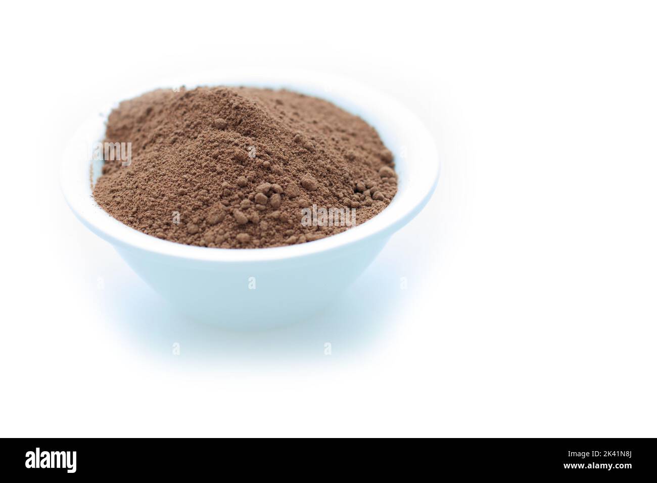 Ground cocoa in white bowl Stock Photo - Alamy