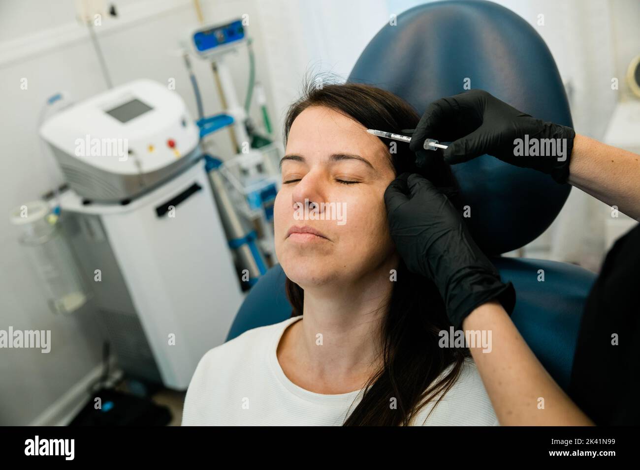 Close up of a woman getting botulinum toxin or fillers on her forehead ...
