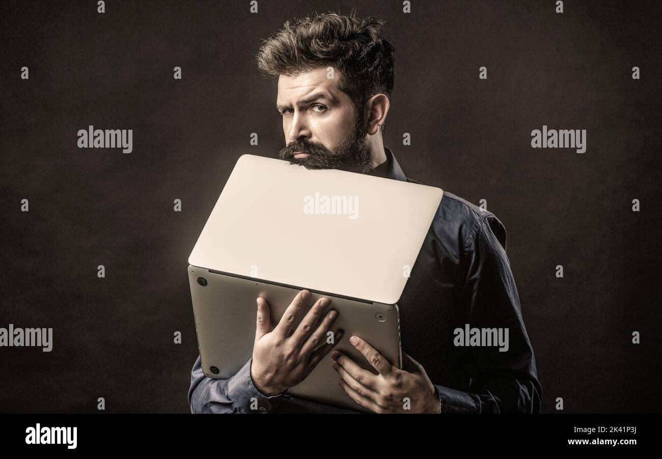 Bearded male businessman holding a computer in his hands isolated on ...