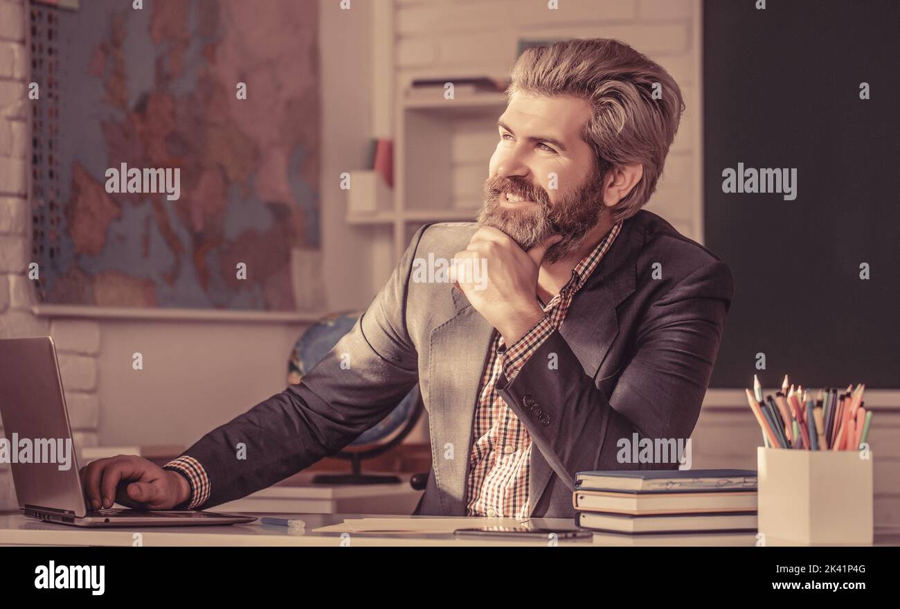 Portrait of confident male teacher in classroom. Young male teacher ...