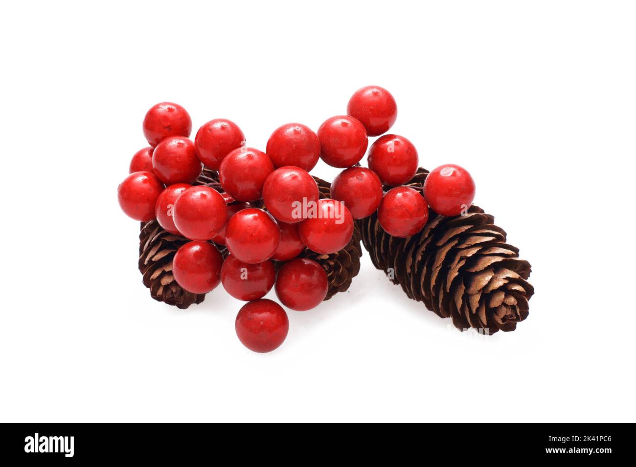 Holly berry sprig with gold pine cone over white background Stock Photo ...