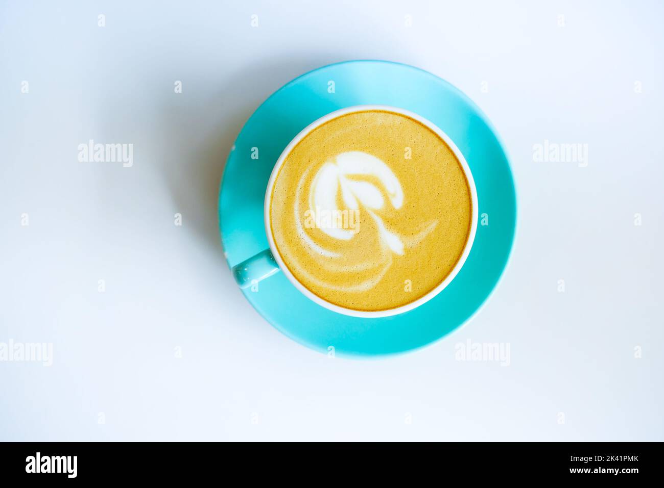 a green color cup of late coffee with flower shape design on top Stock ...