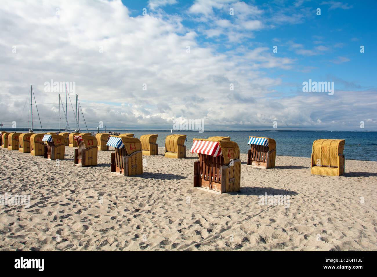 Brown traditional wicker beach baskets on the sandy beach with the ...