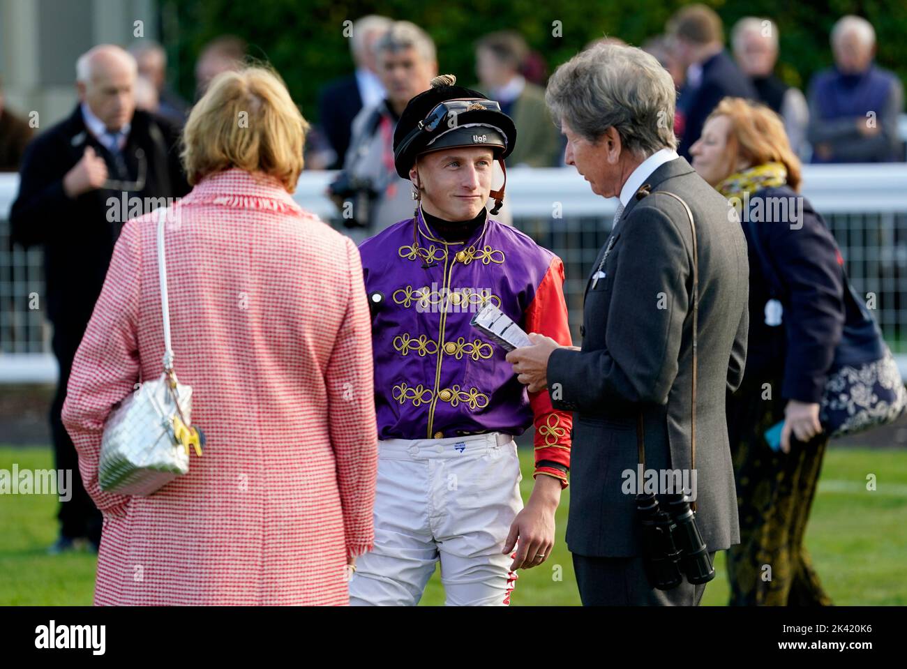 Tom Marquand wearing royal silks in the pre-parade ring speaks to John ...