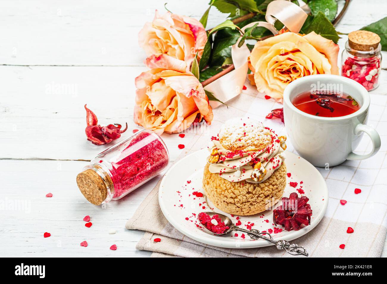 The concept of romantic tea. French Shu cake, hibiscus tea, bouquet of ...