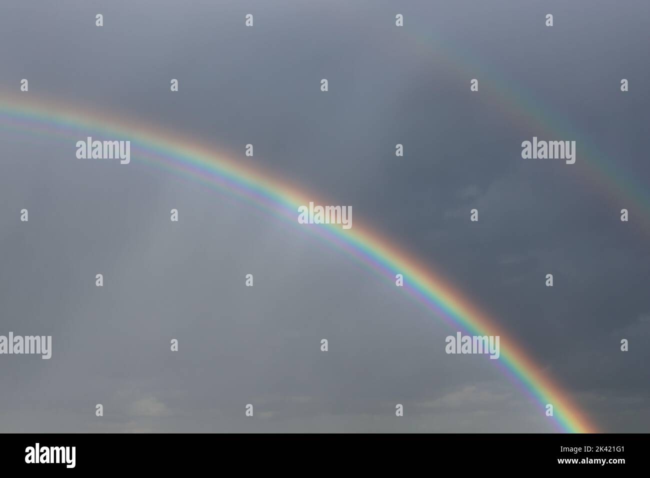Bright double rainbow with dark rain clouds in the nature background ... Bright double rainbow with dark rain clouds in the nature background ...