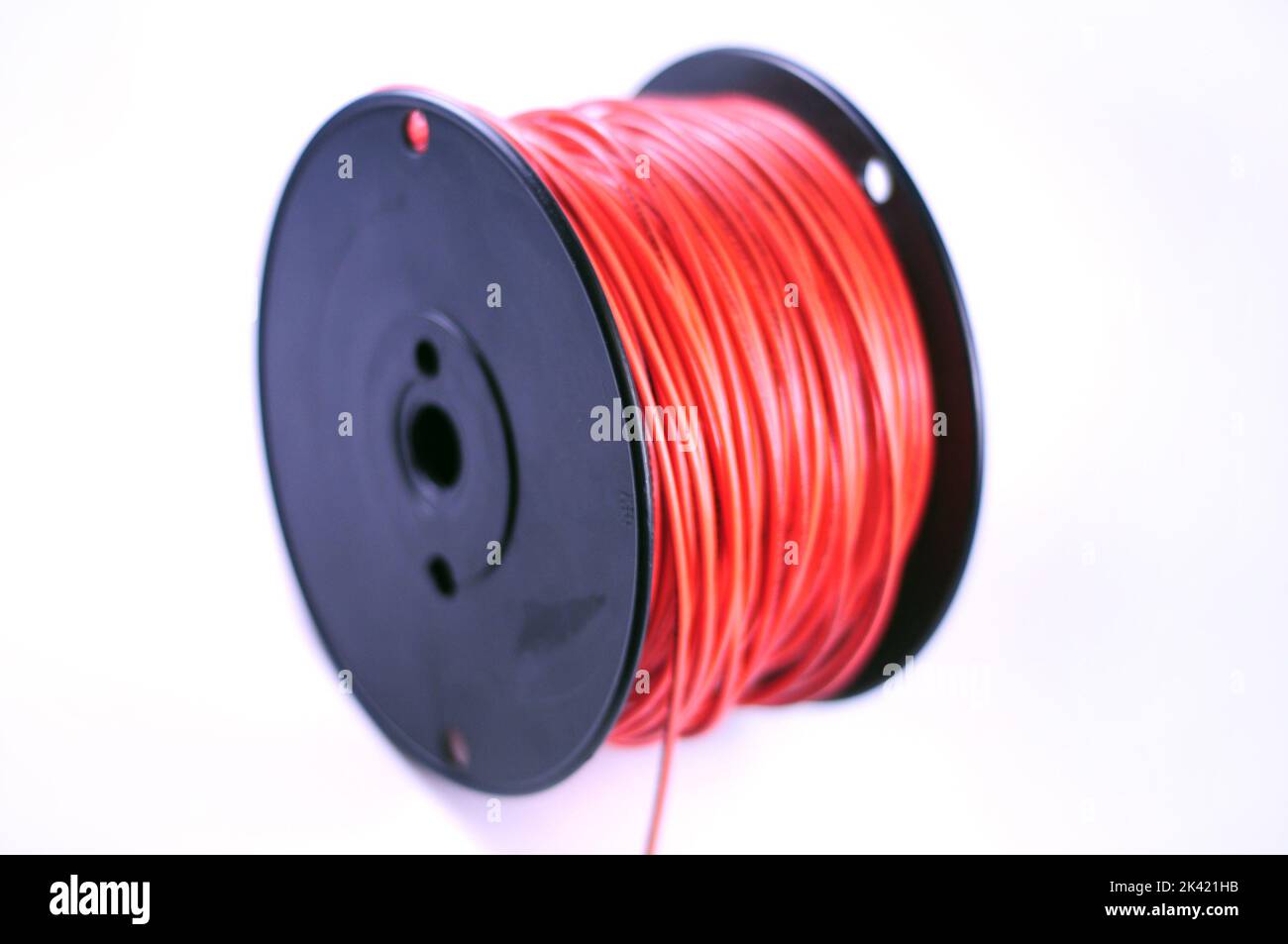 A bobbin of red wire. Isolated on pure white Stock Photo - Alamy