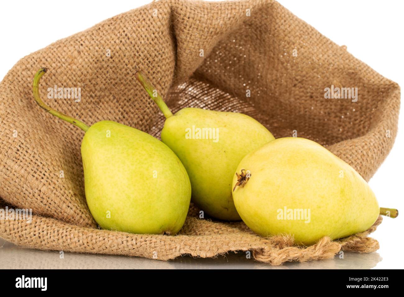 Three ripe green pears in a jute sack, macro, isolated on white ...